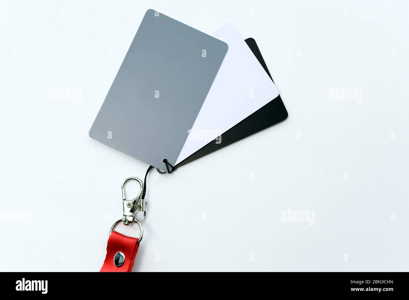 grey card with a red strap, a photographer tool that determines the ...