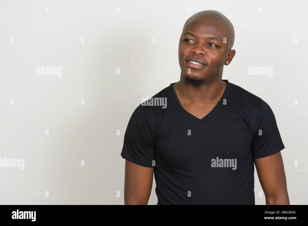 Happy young handsome bald African man thinking Stock Photo - Alamy