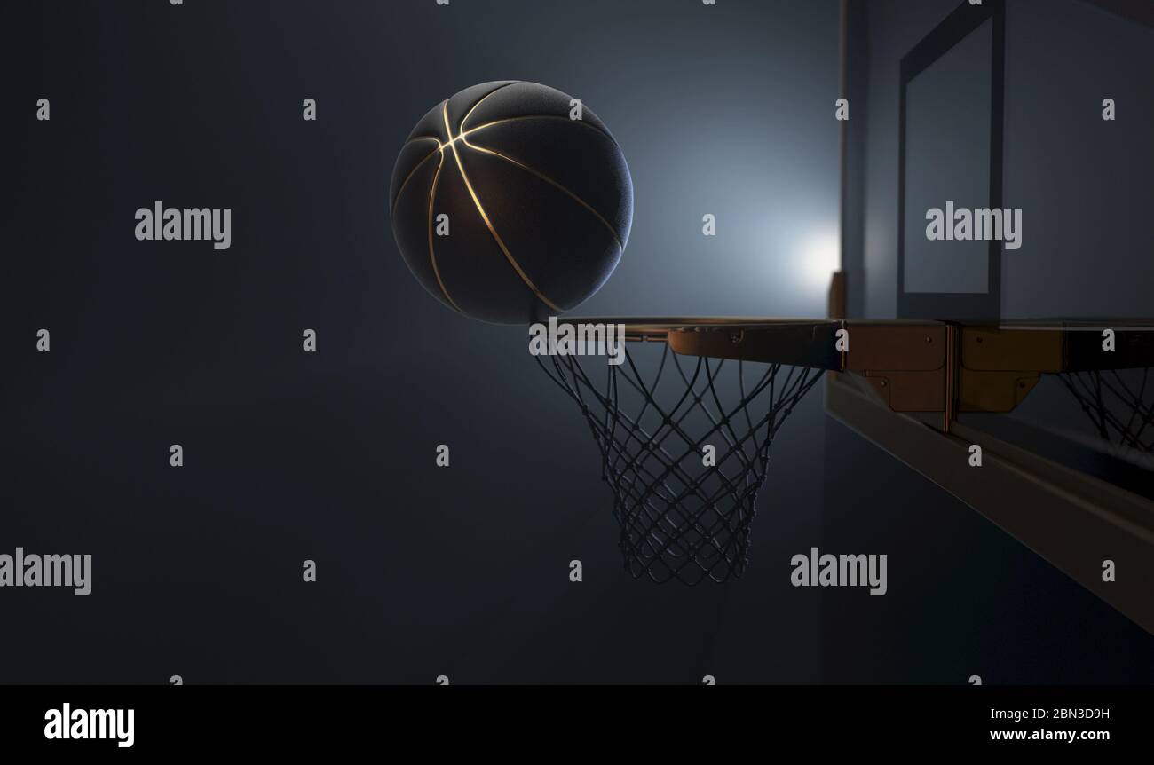 An action shot of a black and gold basketball teetering on the rim of a ...