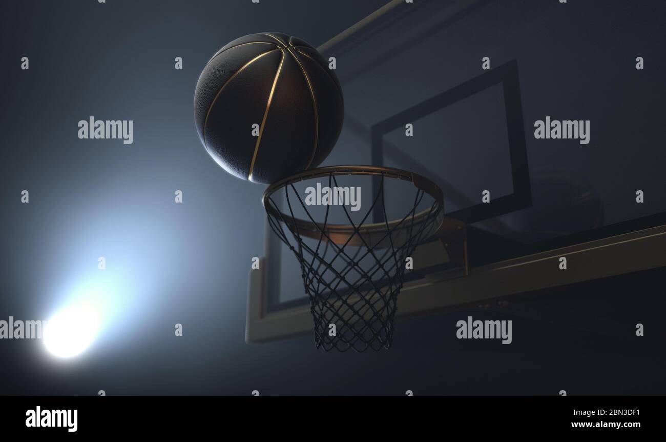 An action shot of a black and gold basketball teetering on the rim of a ...