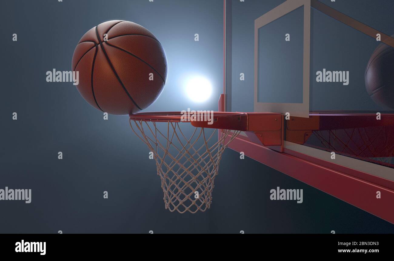 An action shot of a regular basketball teetering on the rim of a red ...