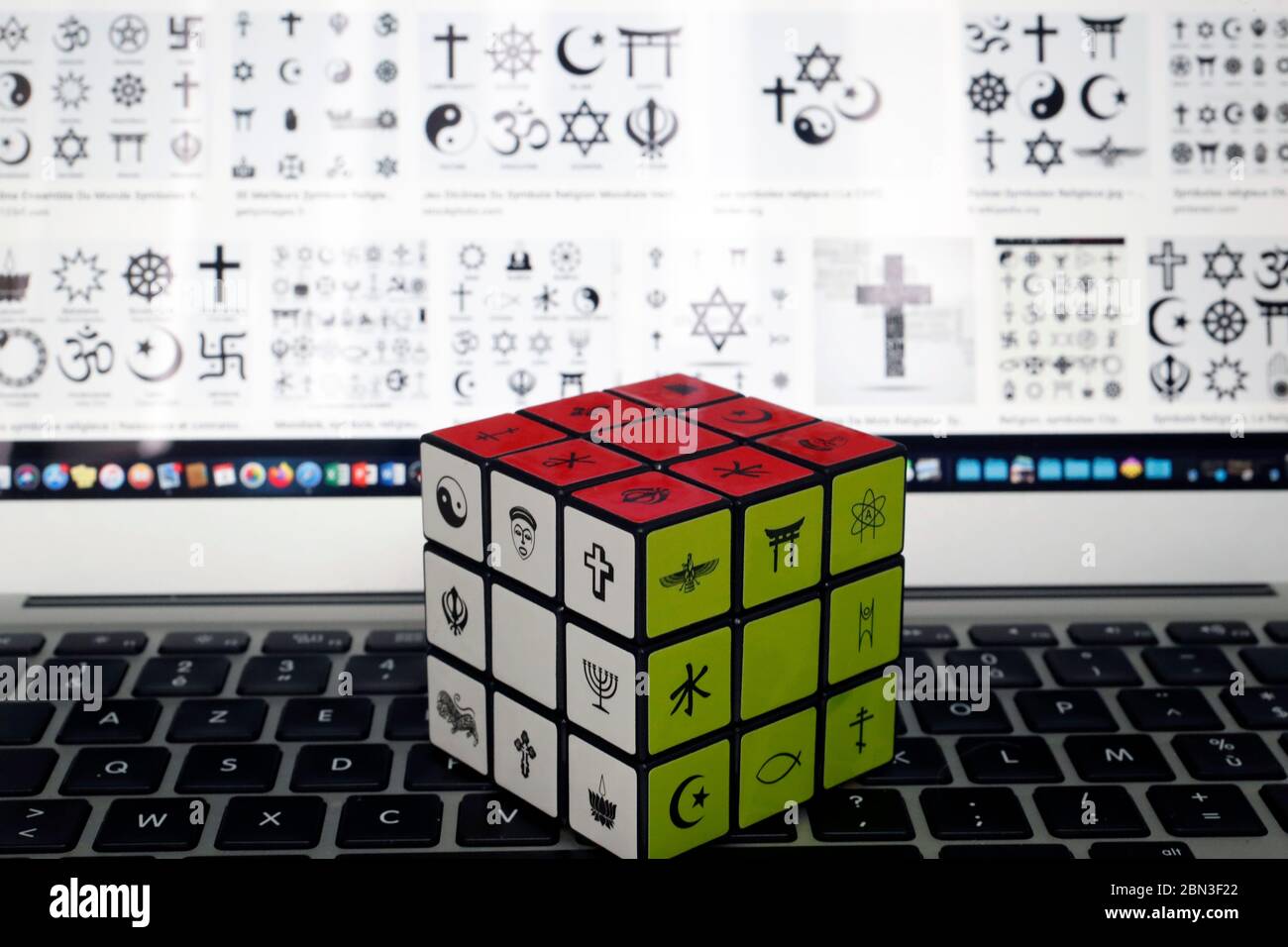 Laptop and Rubik's cube with religious symbols. Interreligious and ...