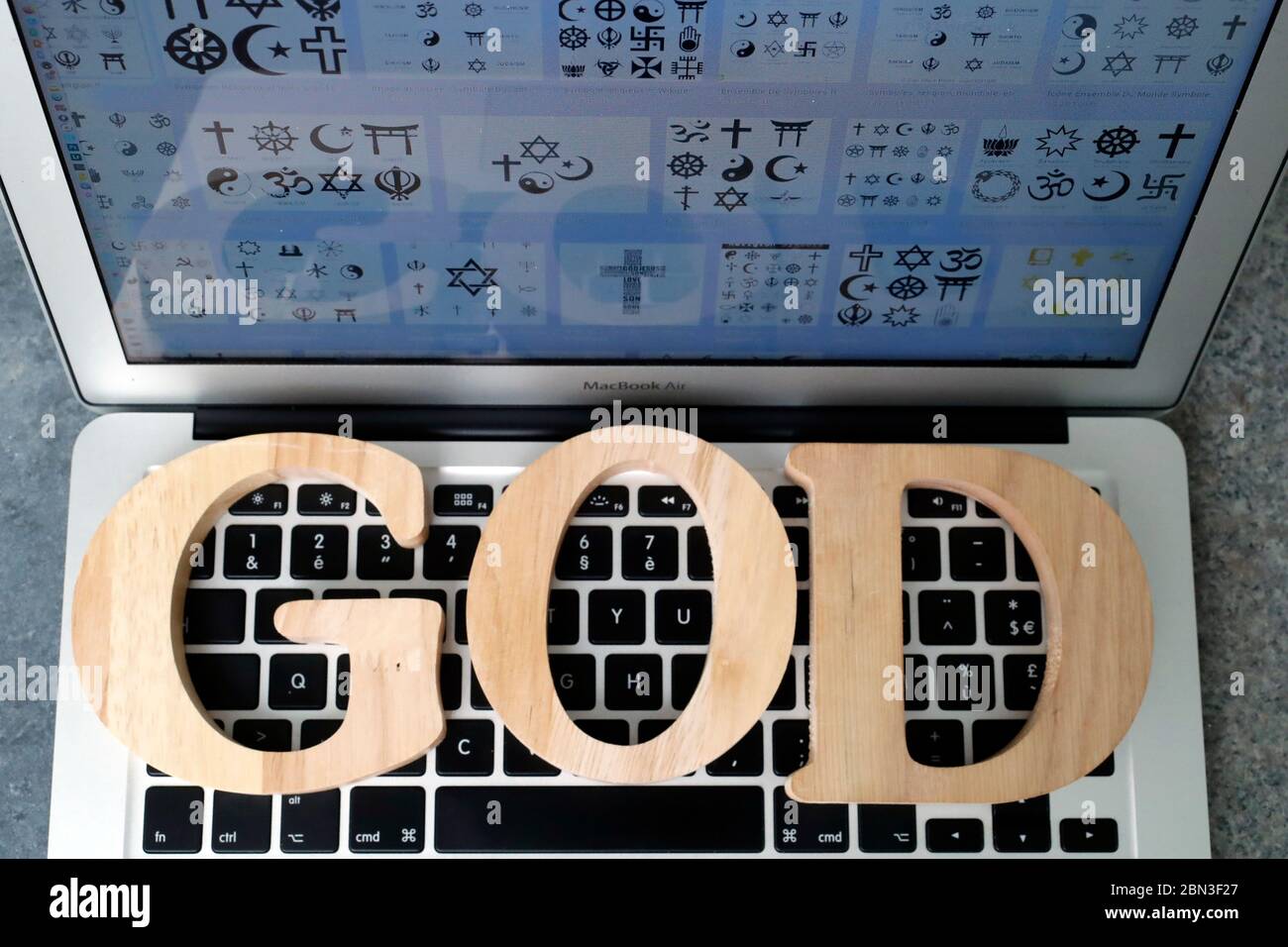 Wooden letters forming the word God on laptop. Interreligious and ...