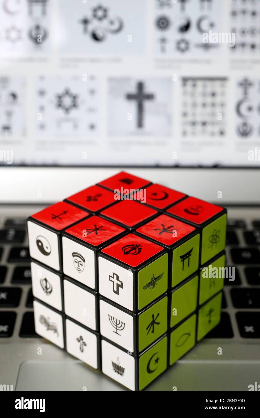 Laptop and Rubik's cube with religious symbols. Interreligious and ...