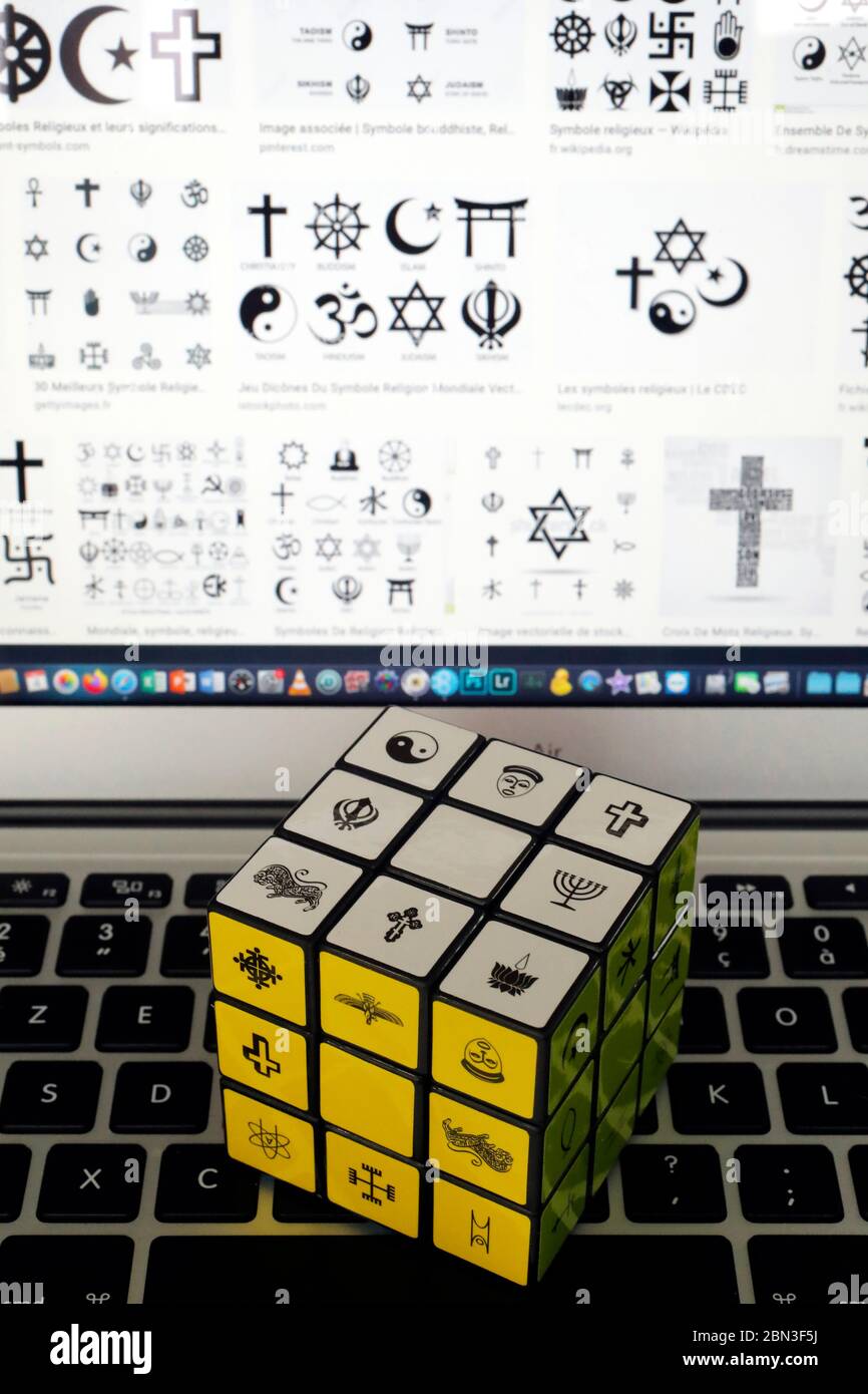Laptop and Rubik's cube with religious symbols. Interreligious and ...