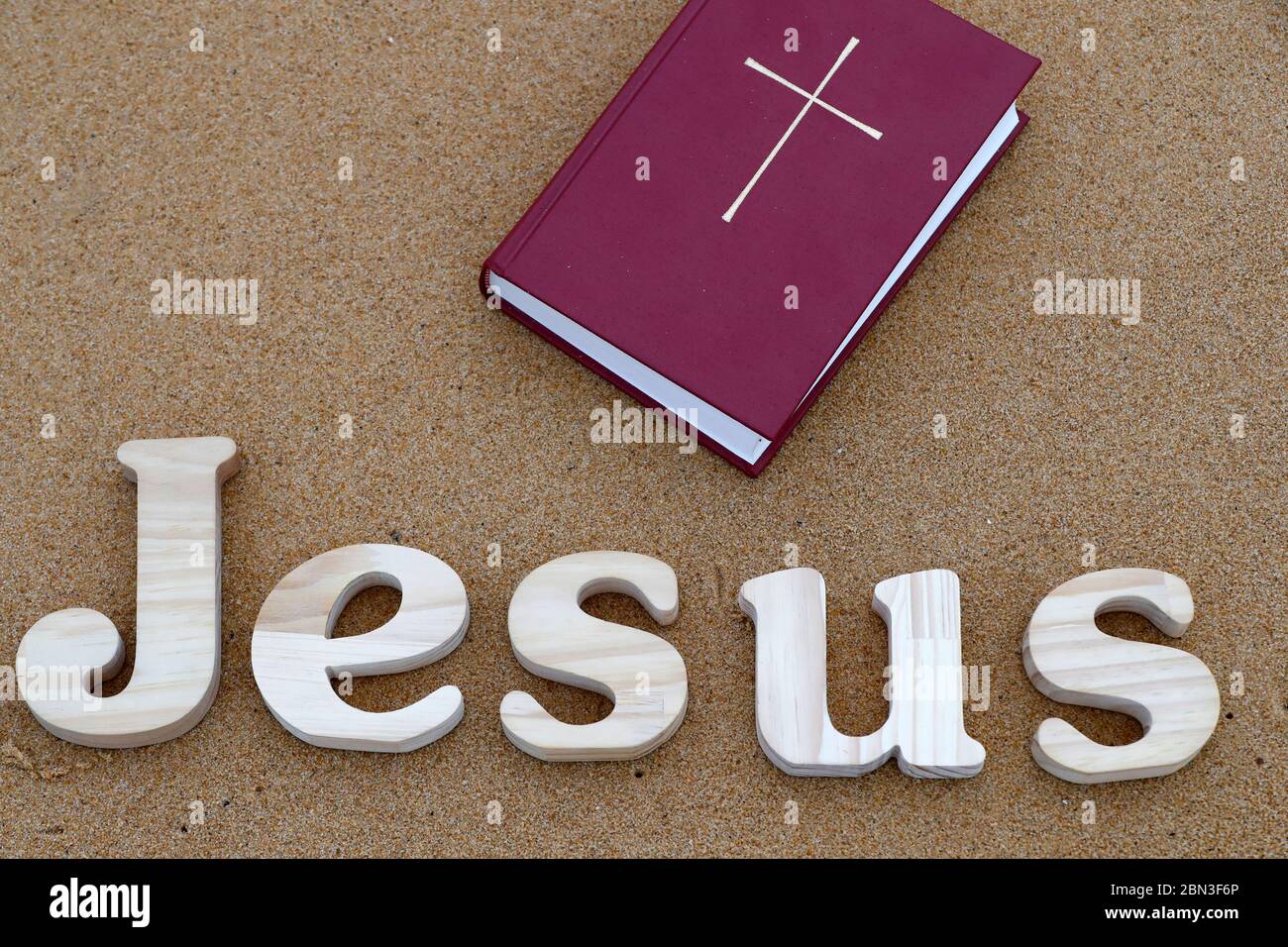 Wooden letters forming the word Jesus with a Bible on a background of ...