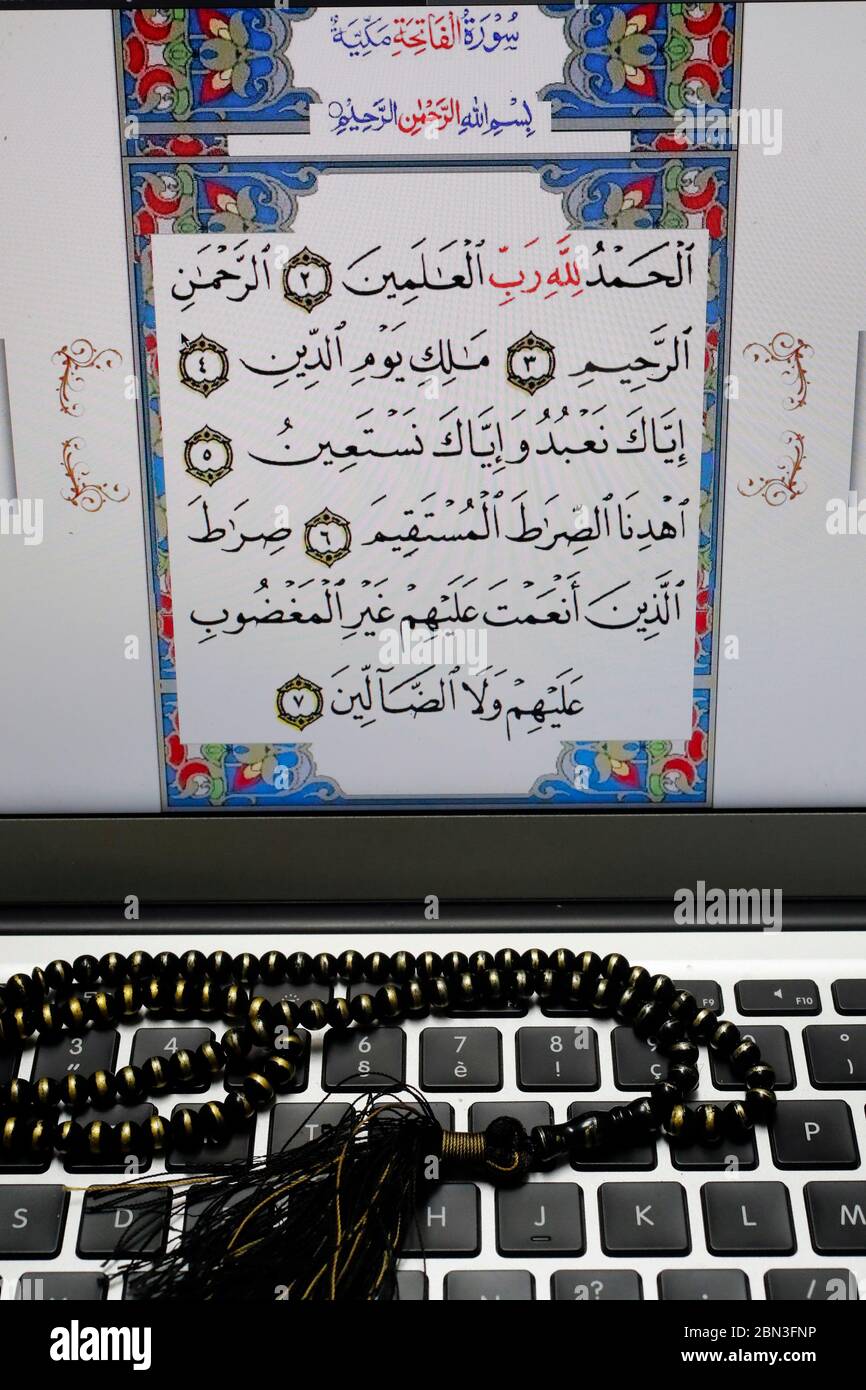 Digital Quran on a laptop with prayer beads on the keyboard. France ...