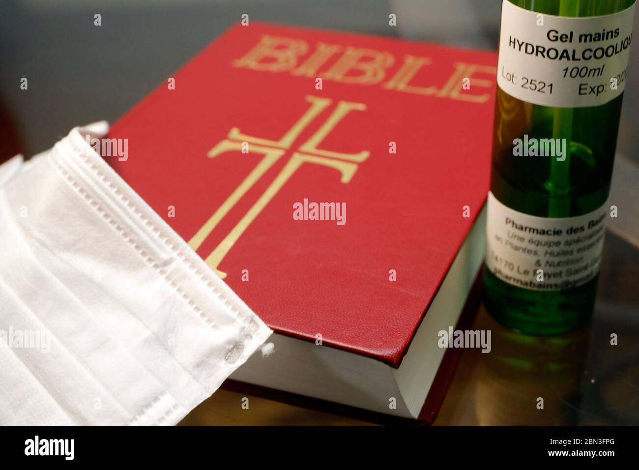 Religion and coronavirus ( COVID-19). Bible, disposable surgical mask ...