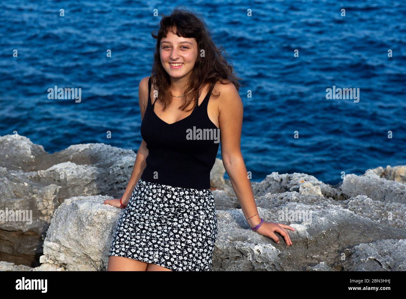 Italian girl sitting on rocks in Salento, Italy Stock Photo - Alamy