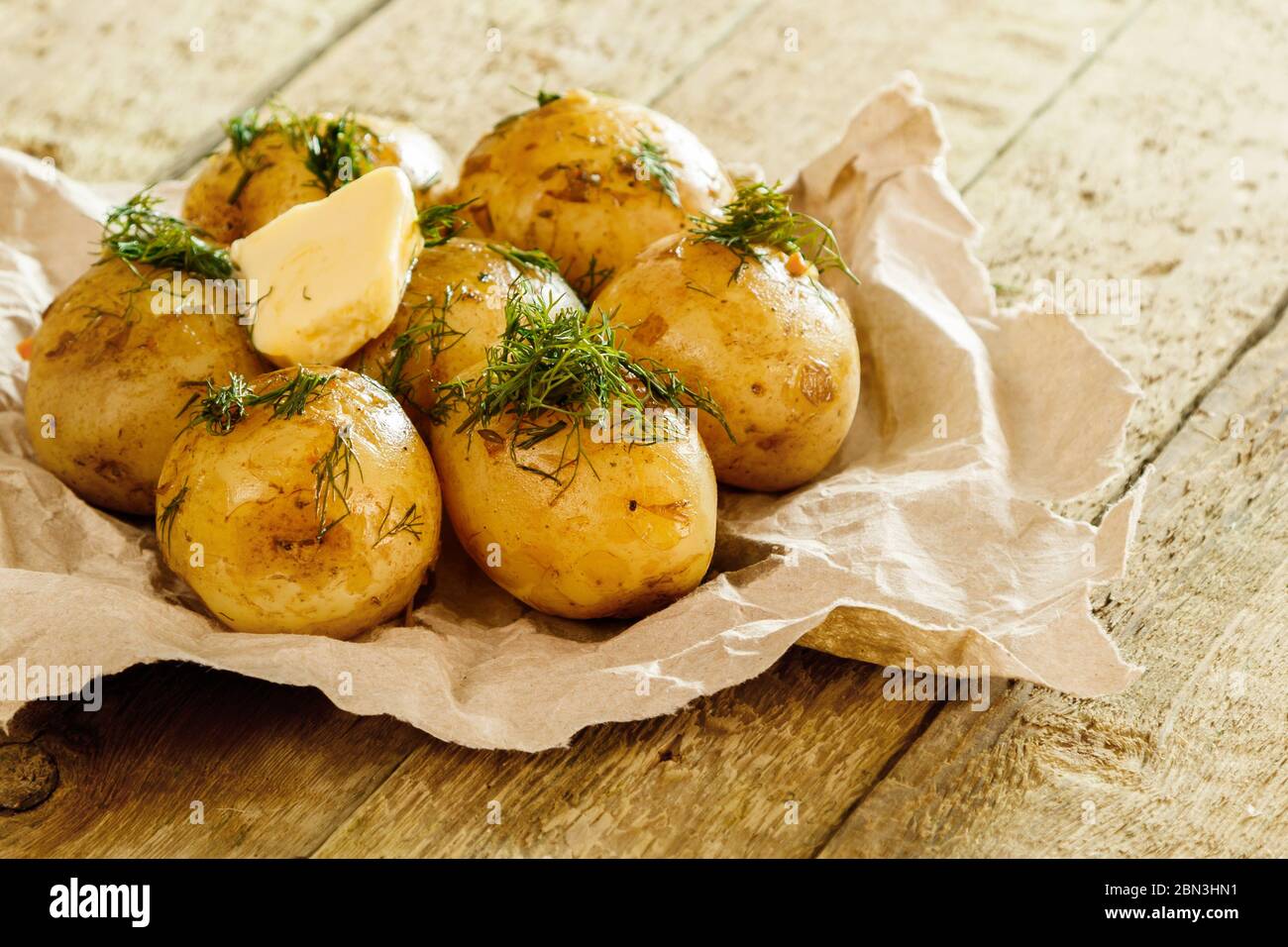 Roasted potatoes with dill on wooden table Stock Photo - Alamy