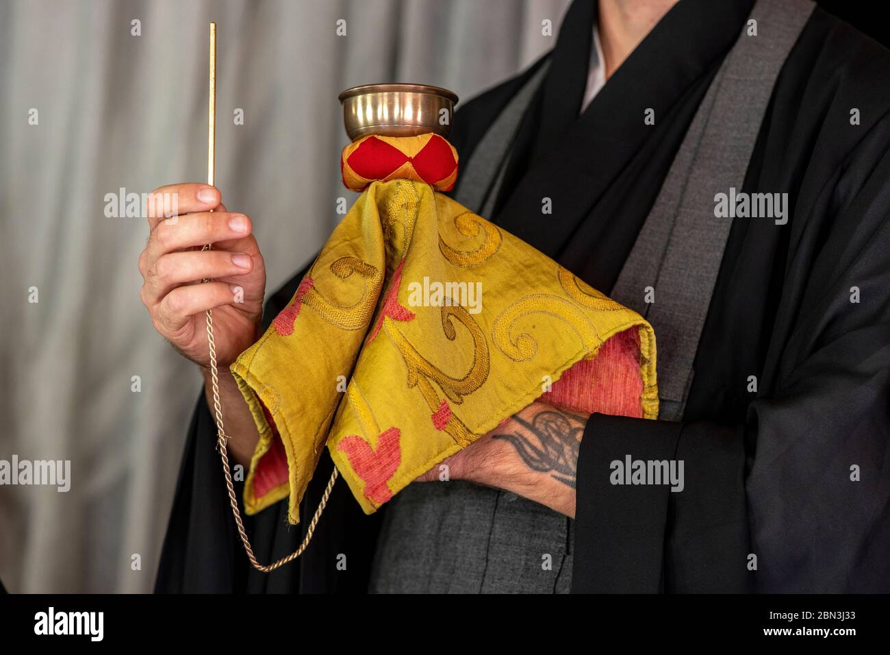 Zen monk sounding a hand-bell called inkin during a buddhist ceremony ...