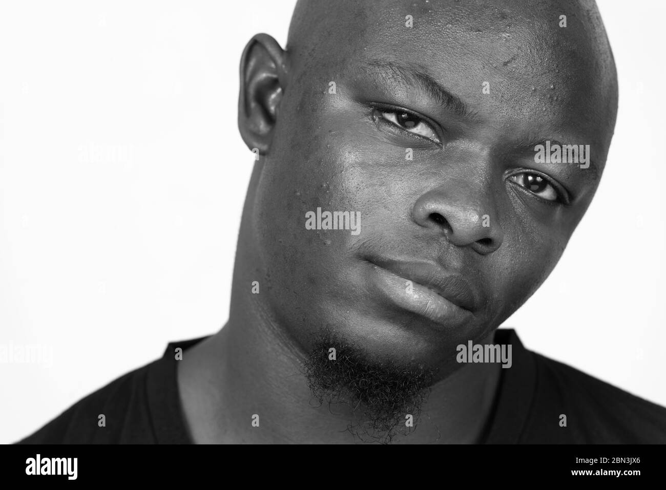 Face of young handsome bald African man with beard in black and white ...