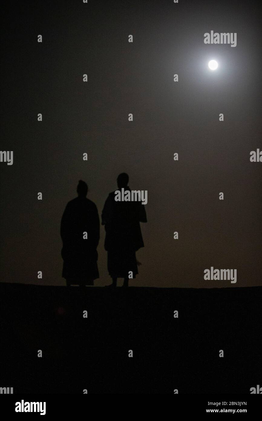 Buddhist monks standing under the moonlight during a zen retreat in the ...