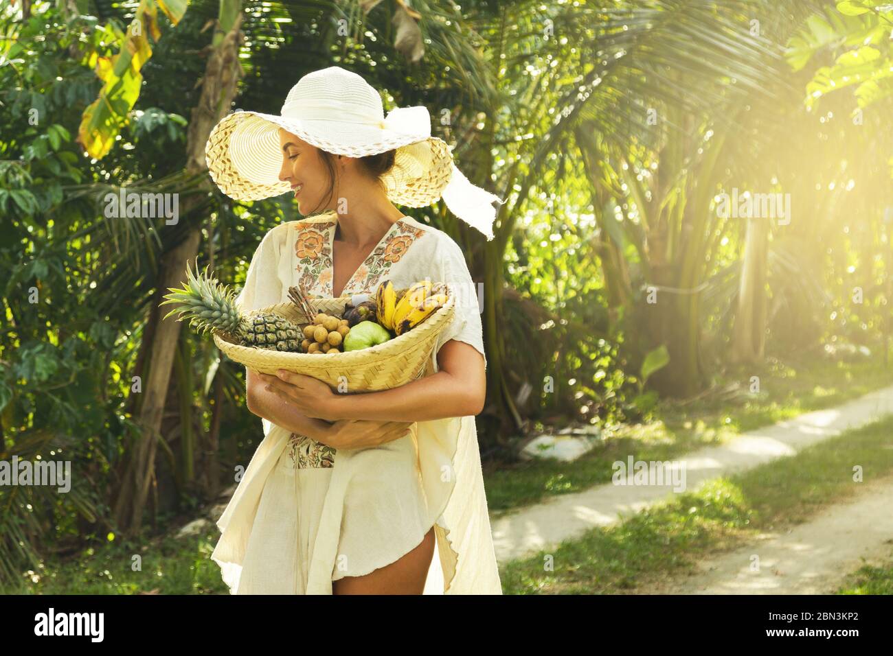Beautiful woman wearing broad-brim hat in the tropical garden with a ...