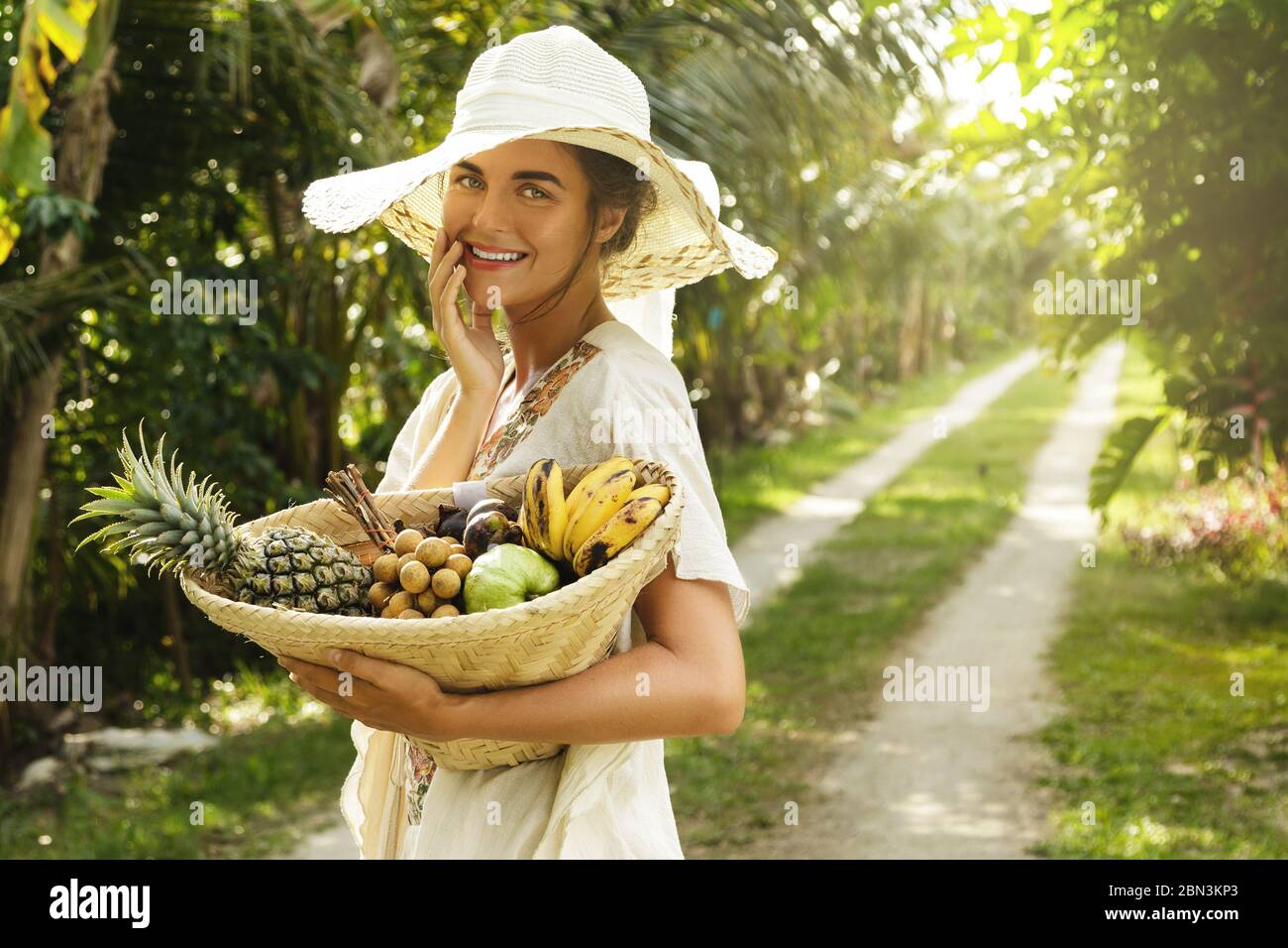 Beautiful woman wearing broad-brim hat in the tropical garden with a ...