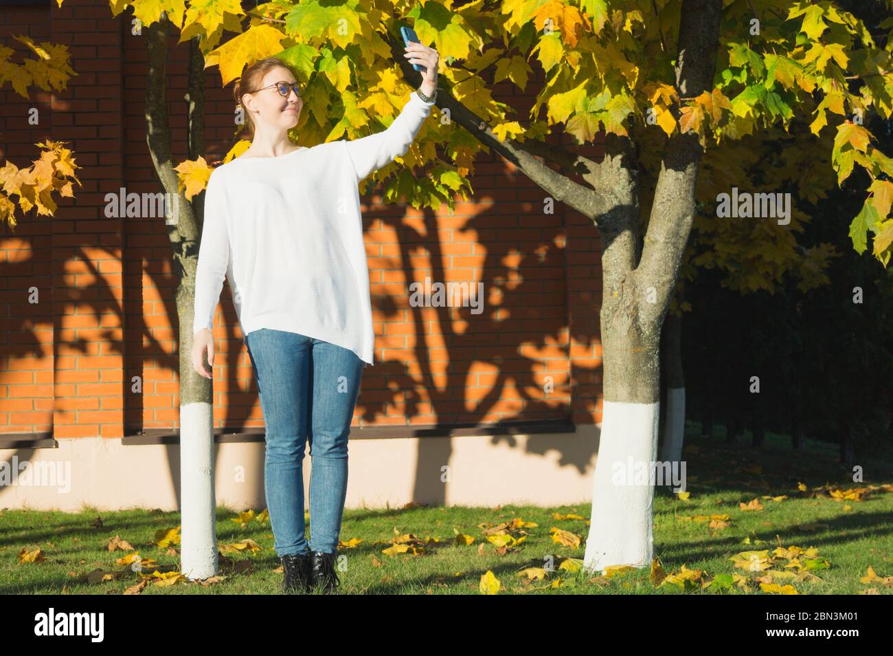 A woman is smiling while video chatting on her mobile phone. She is ...