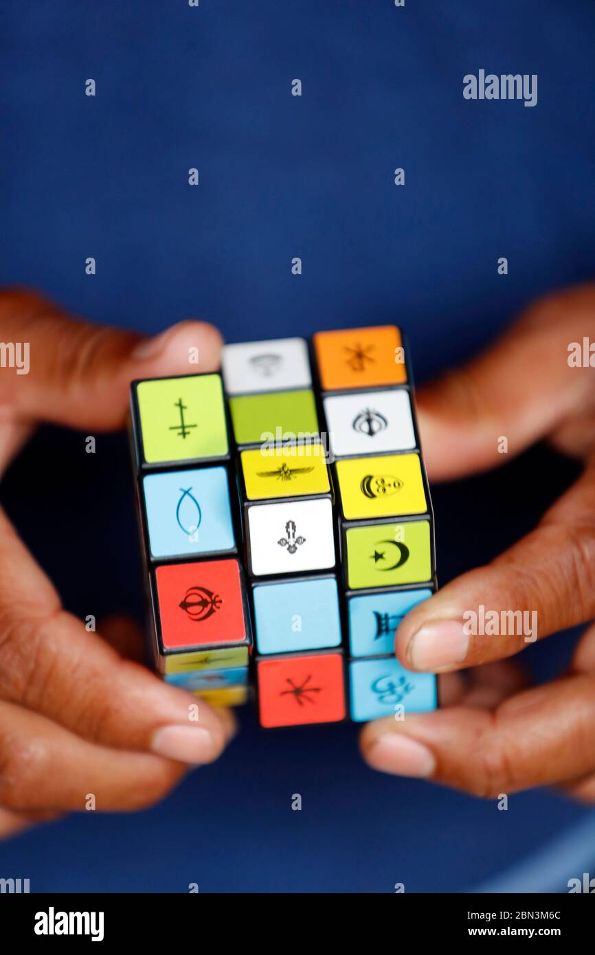 African man with a Rubik's cube with religious symbols. Interreligious ...