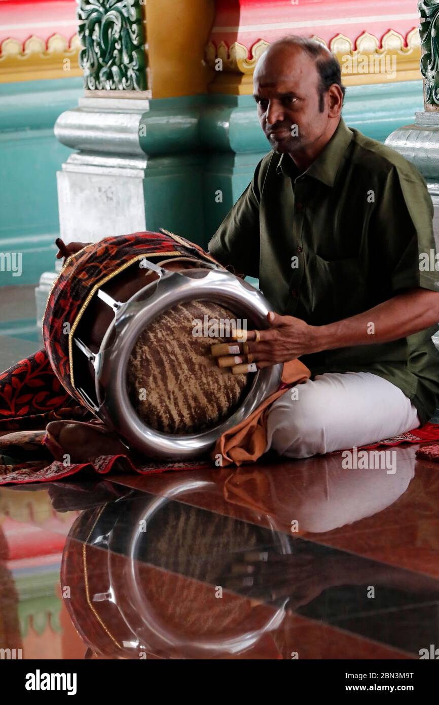 Sri Mahamariamman Hindu Temple. Musician playing a Thavil, a tradional ...