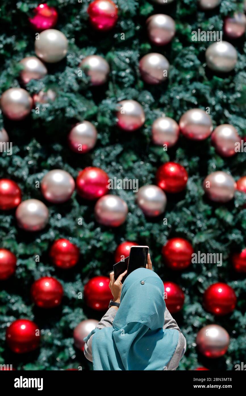 Christmas tree at Suria Mall, Petronas Towers. Muslim woman making ...