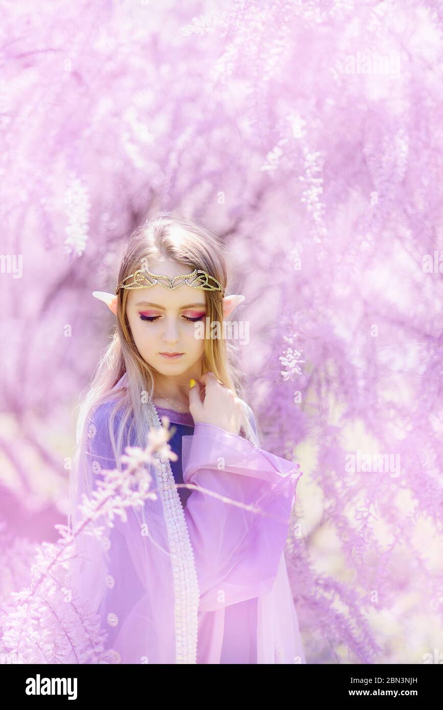 Beautiful romantic blonde girl with blue eyes posing in forest ...