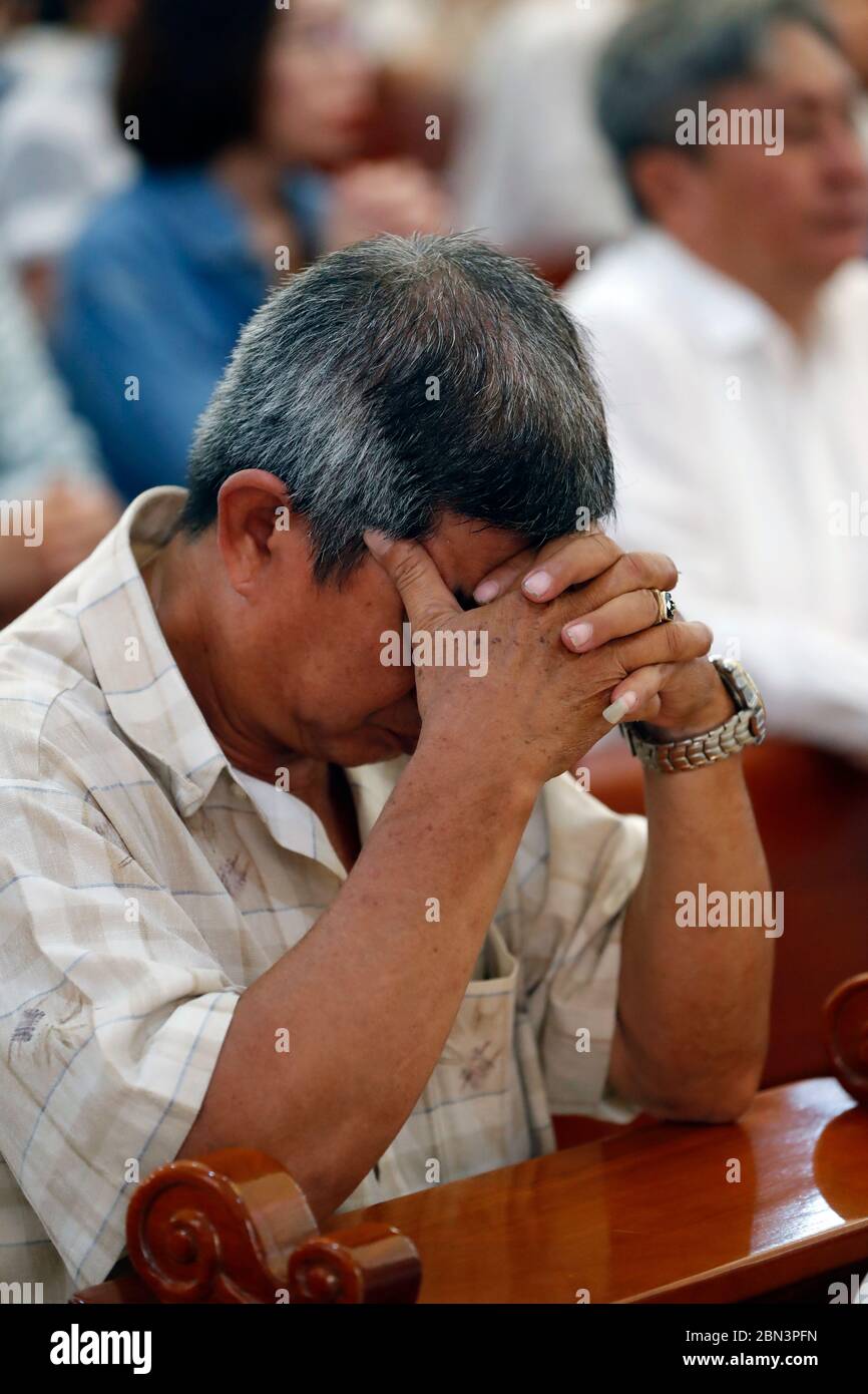 Catholic church. Sunday mass. Man praying. Ho Chi Minh City. Vietnam ...
