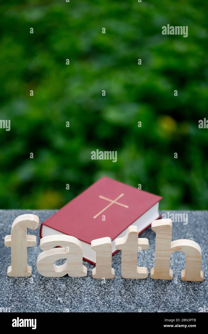 Wooden letters forming the word FAITH and Bible. Christian symbol Stock ...