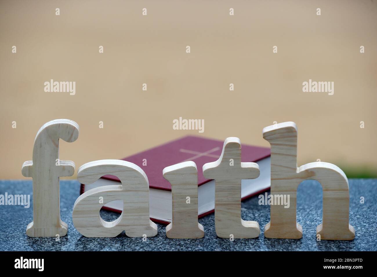 Wooden letters forming the word FAITH and Bible. Christian symbol Stock ...