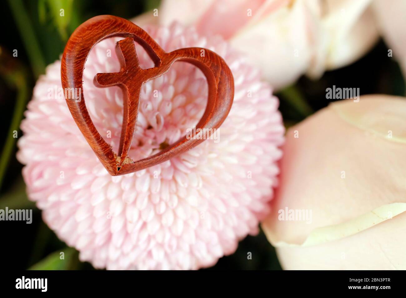 Christian symbol placed on a flower. Cross inside a heart Stock Photo ...
