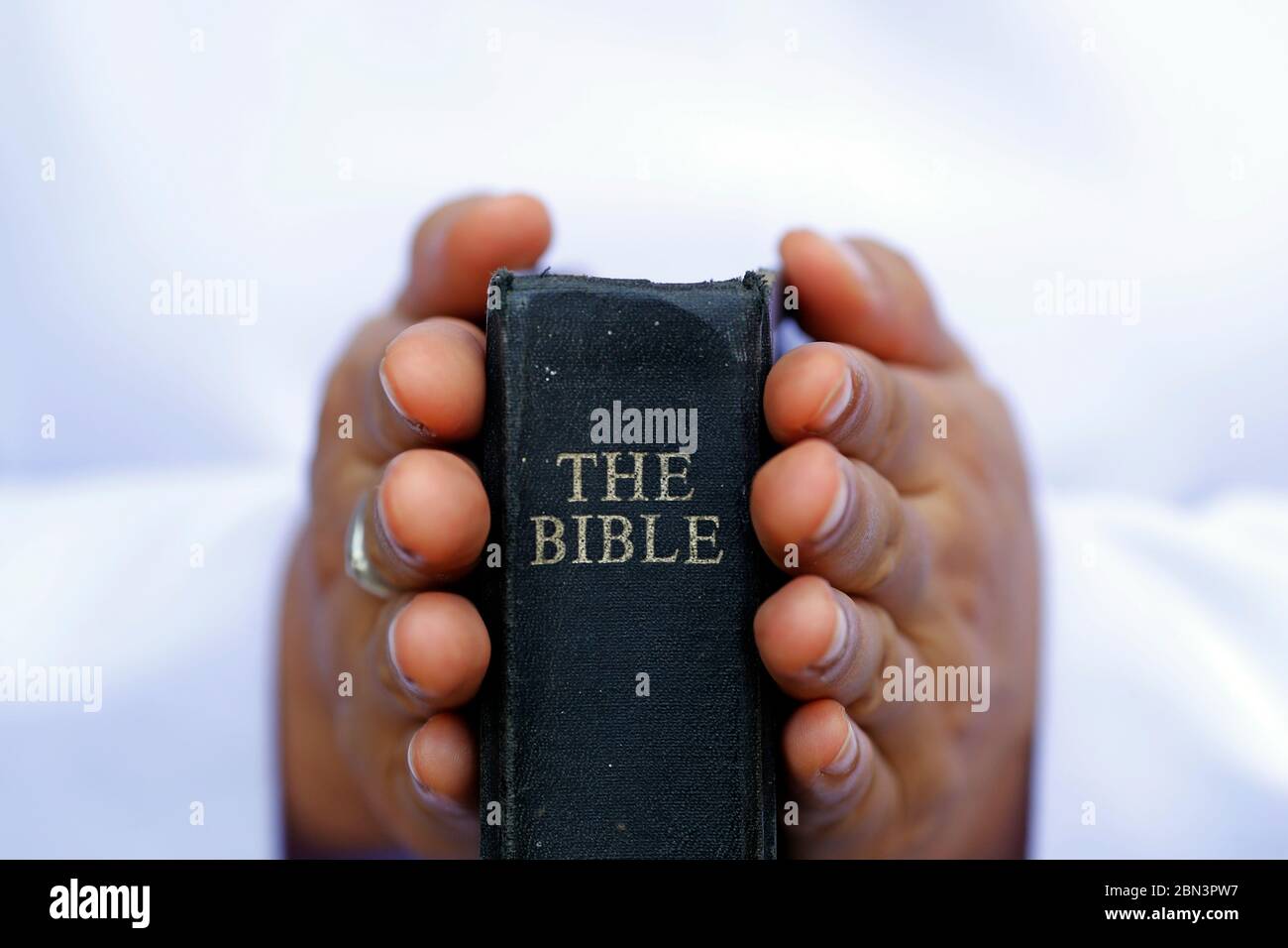 Praying hands holding the Bible. Close-up. Vietnam Stock Photo - Alamy