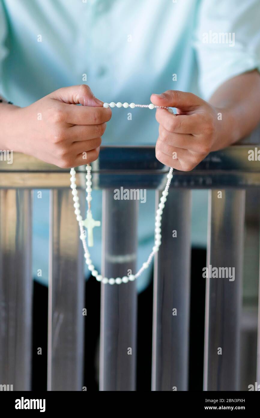 Young catholic woman praying the rosary beads. Vietnam Stock Photo - Alamy