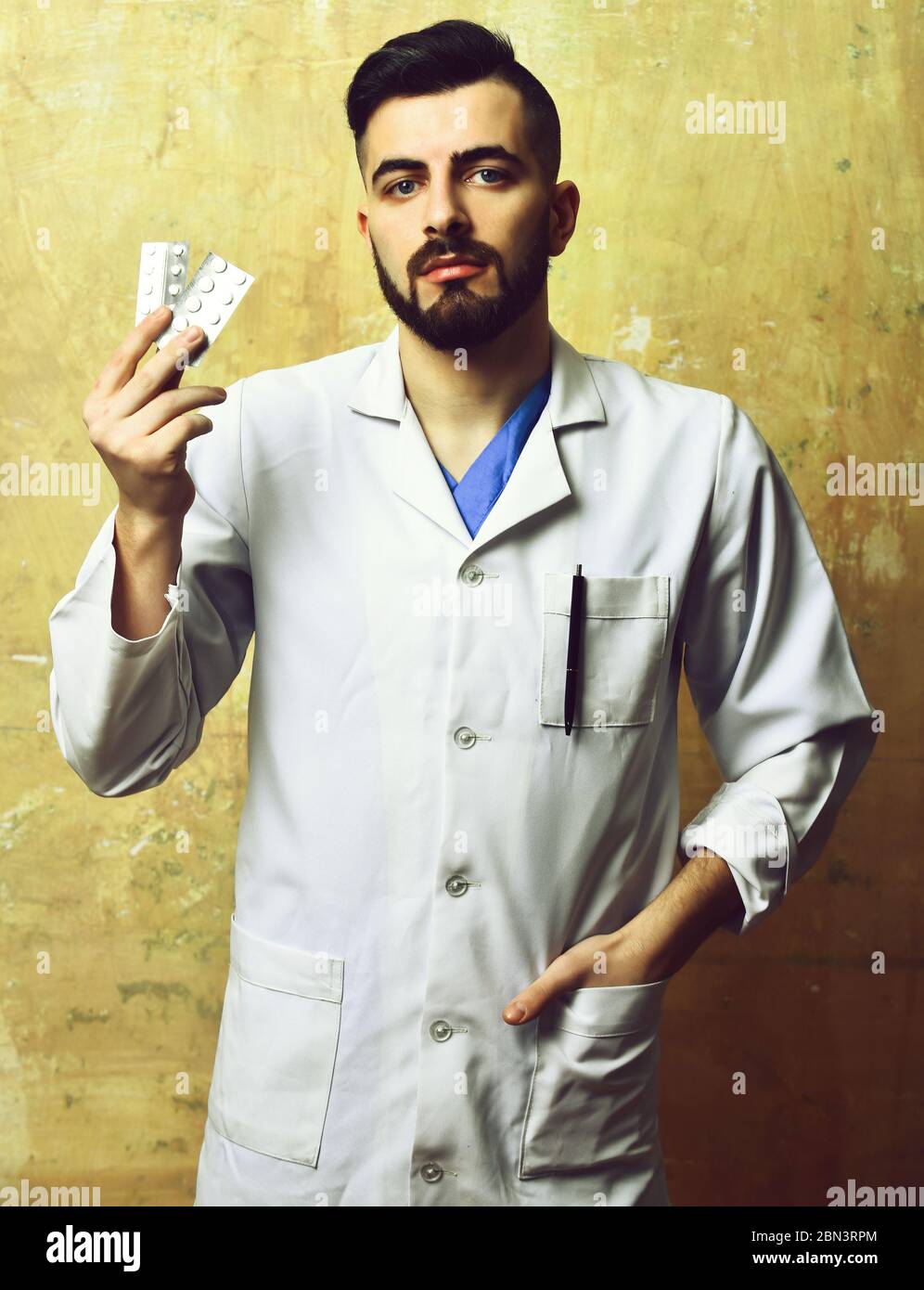 Doctor with beard and serious face expression holds two blisters of ...