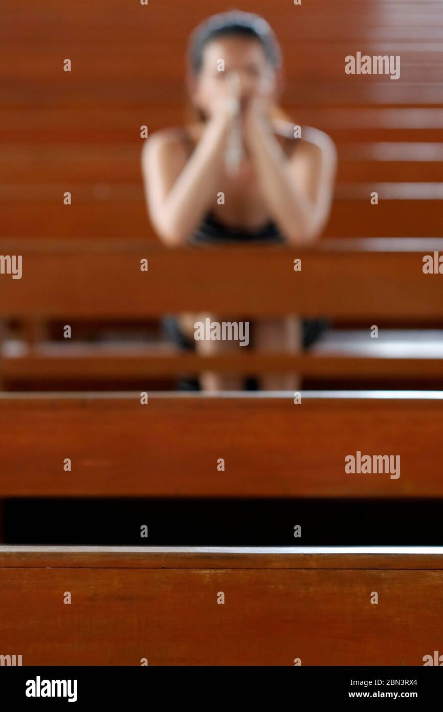 Catholic woman praying alone in a church Stock Photo - Alamy