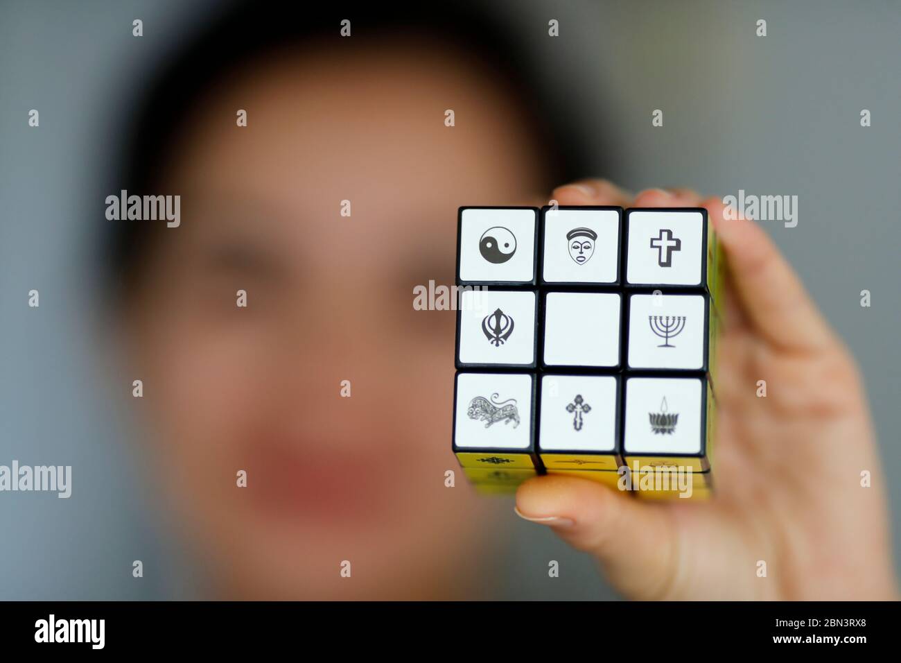 Woman with a Rubik's cube with religious symbols. Interreligious and ...