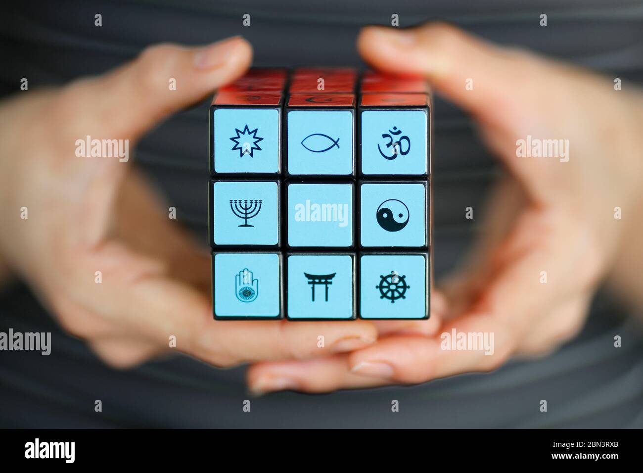 Woman with a Rubik's cube with religious symbols. Interreligious and ...
