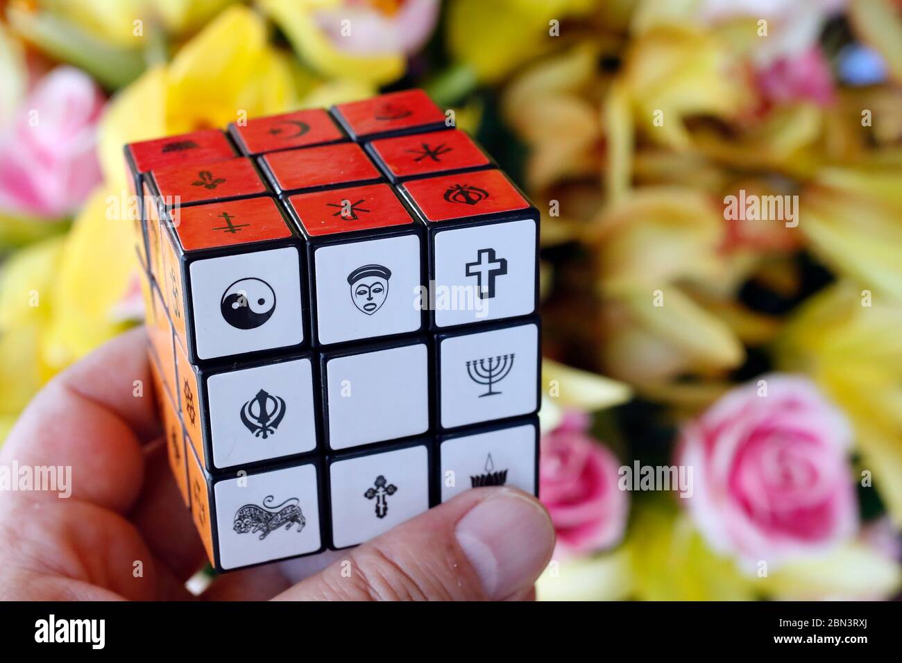 Man with a Rubik's cube with religious symbols. Interreligious and ...