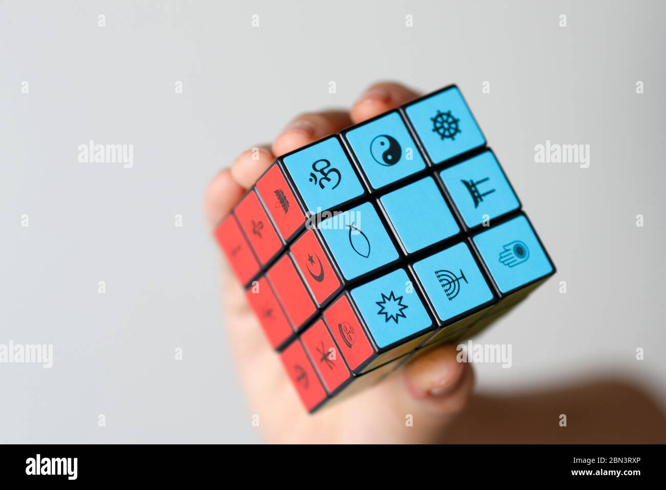 Woman with a Rubik's cube with religious symbols. Interreligious and ...