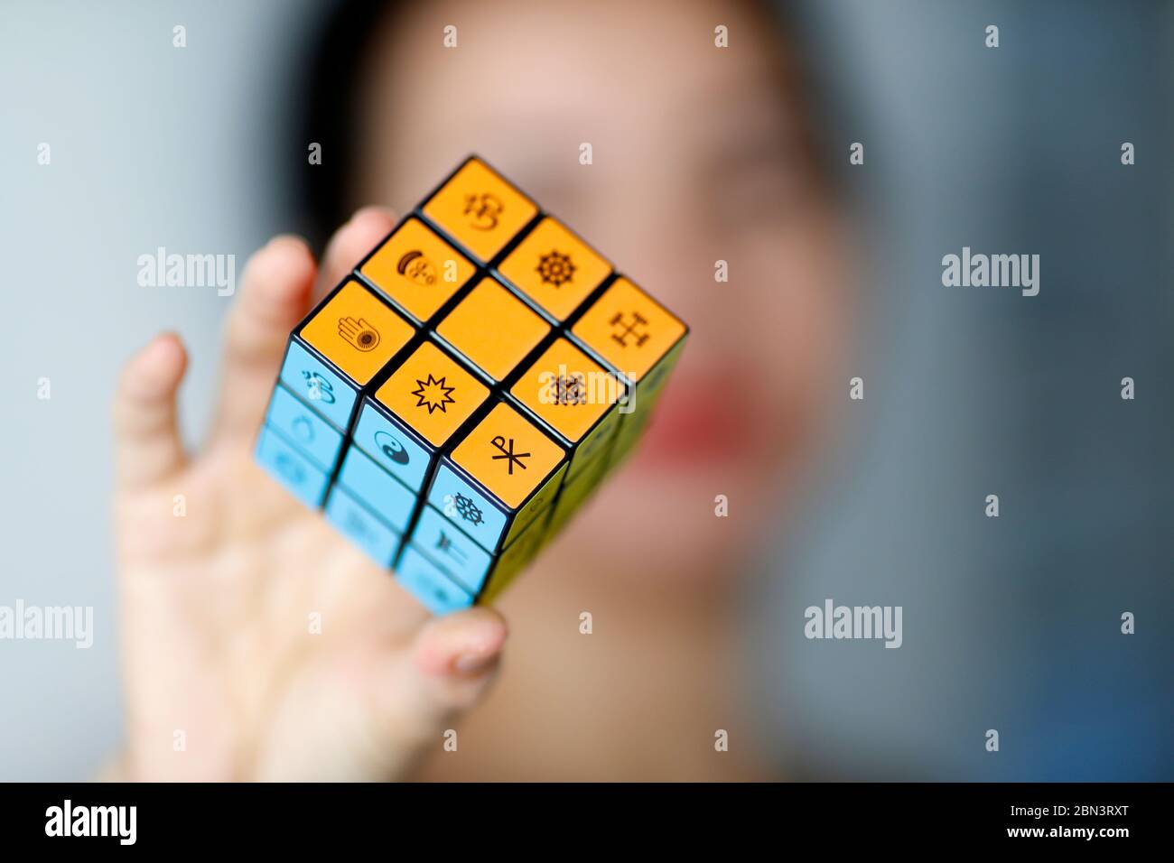 Woman with a Rubik's cube with religious symbols. Interreligious and ...