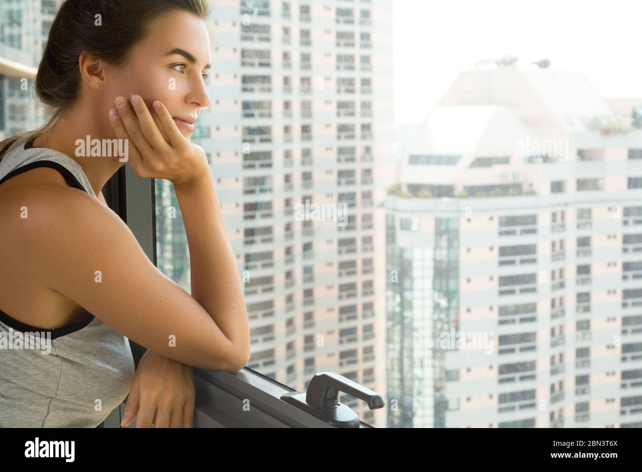 Young and beautiful woman in her flat is looking into the window Stock ...