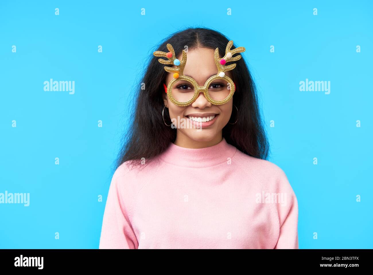Pretty woman in funny party glasses posing over blue background. Fun ...