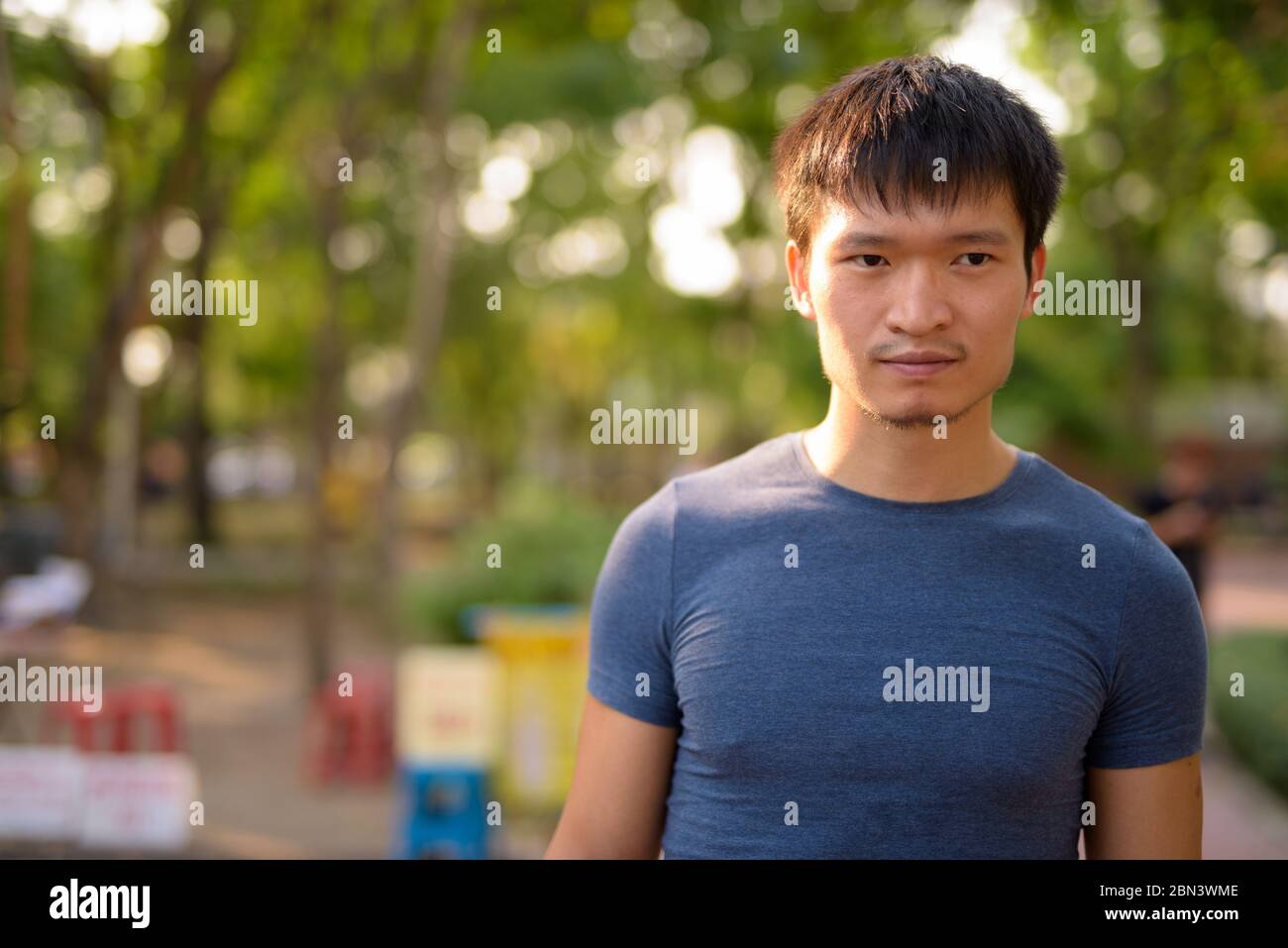 Portrait of young Asian man at the park outdoors Stock Photo - Alamy