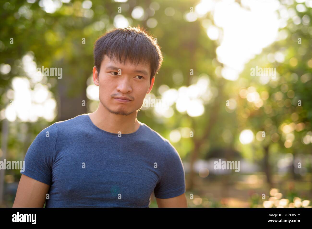 Portrait of young Asian man at the park outdoors Stock Photo - Alamy