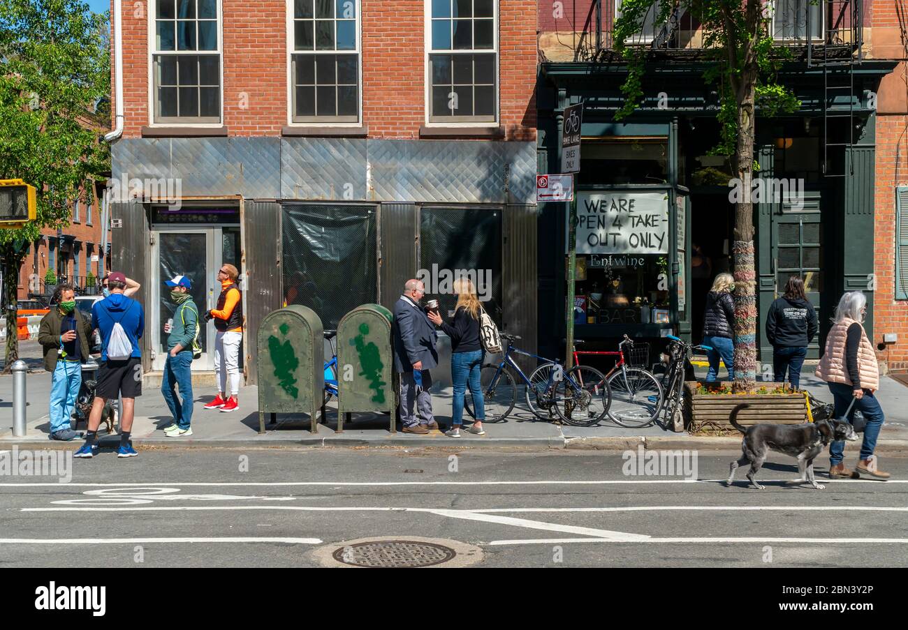 People congregate outside of a restaurant providing take out in the ...
