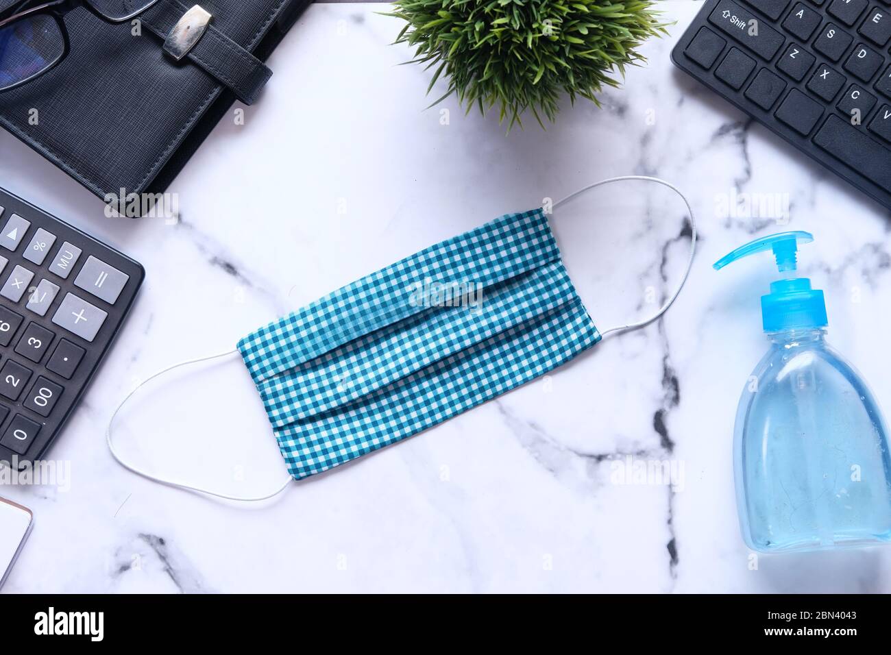 surgical face mask and hand sanitizer office desk Stock Photo - Alamy
