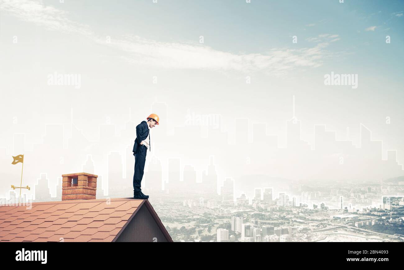 Engineer man standing on roof and looking down. Mixed media Stock Photo ...