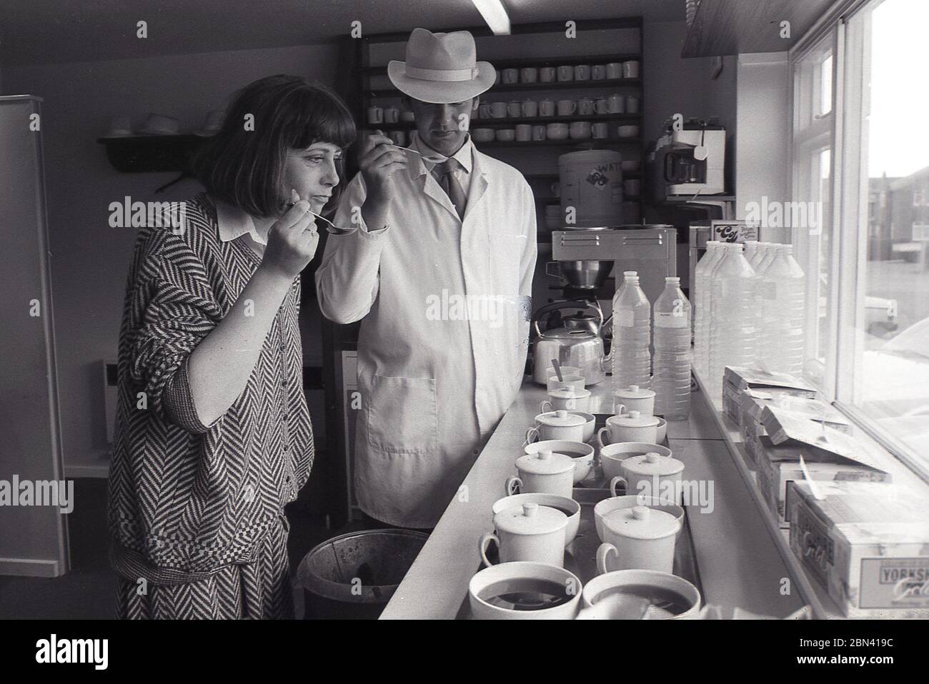 1980s, tea tasting session.....a man in a white coat and hat, a trained ...