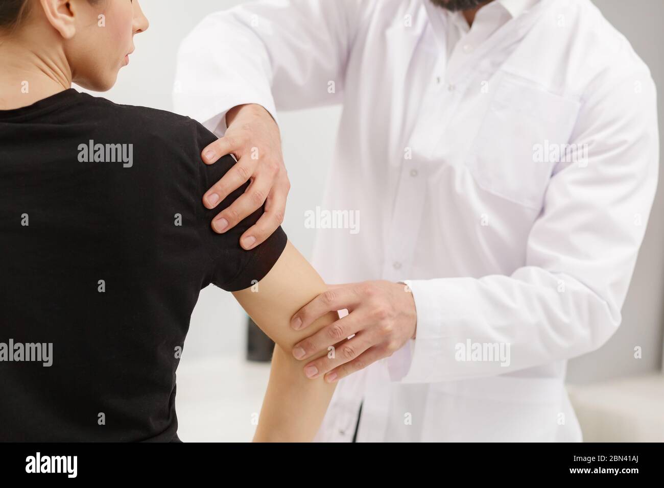 Male doctor examining female patient suffering from elbow pain. Medical ...