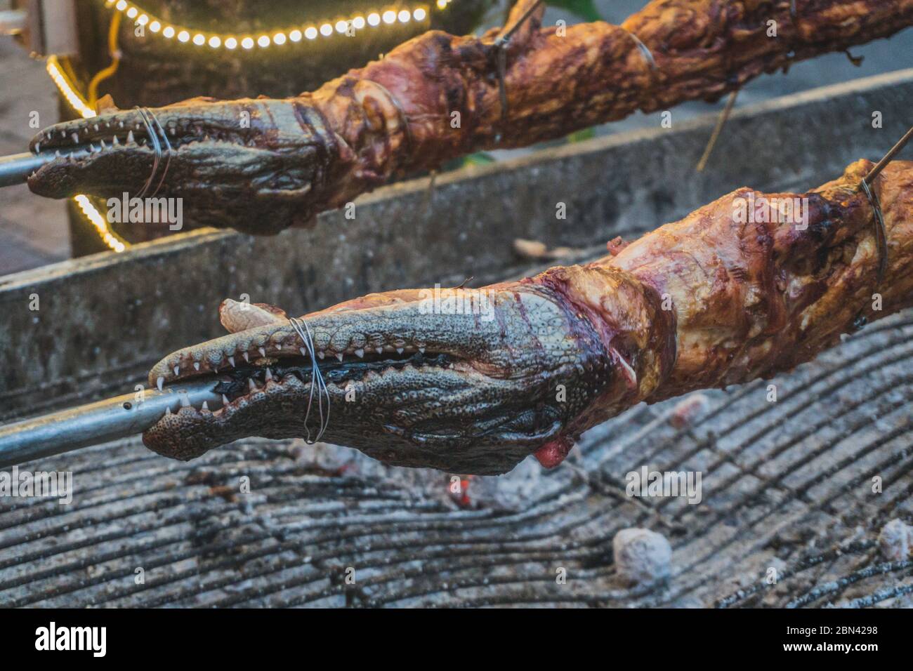 Grilled crocodile on the open fire at sea food restaurant, exotic meals ...