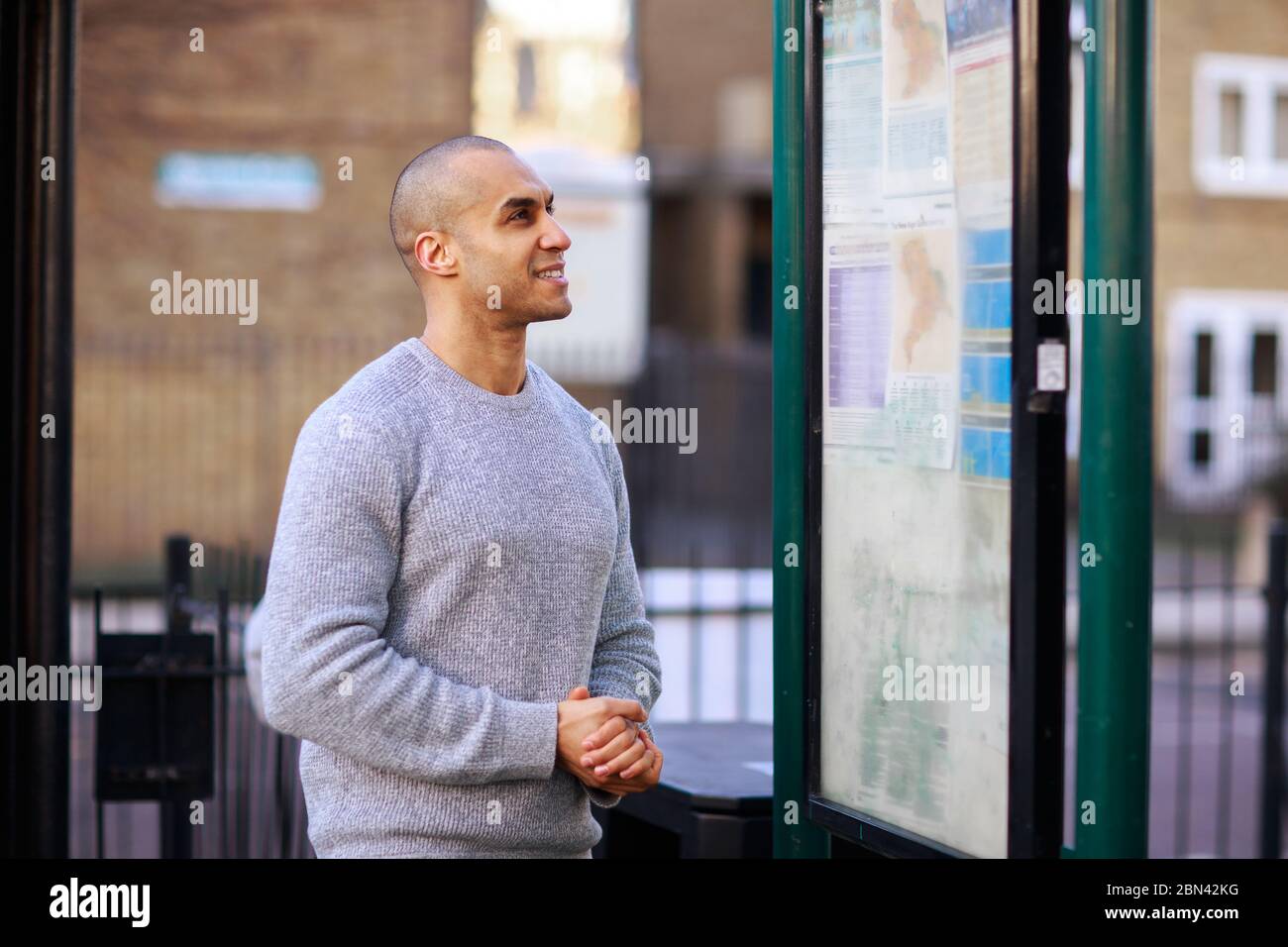 young man looking at a notice board Stock Photo - Alamy