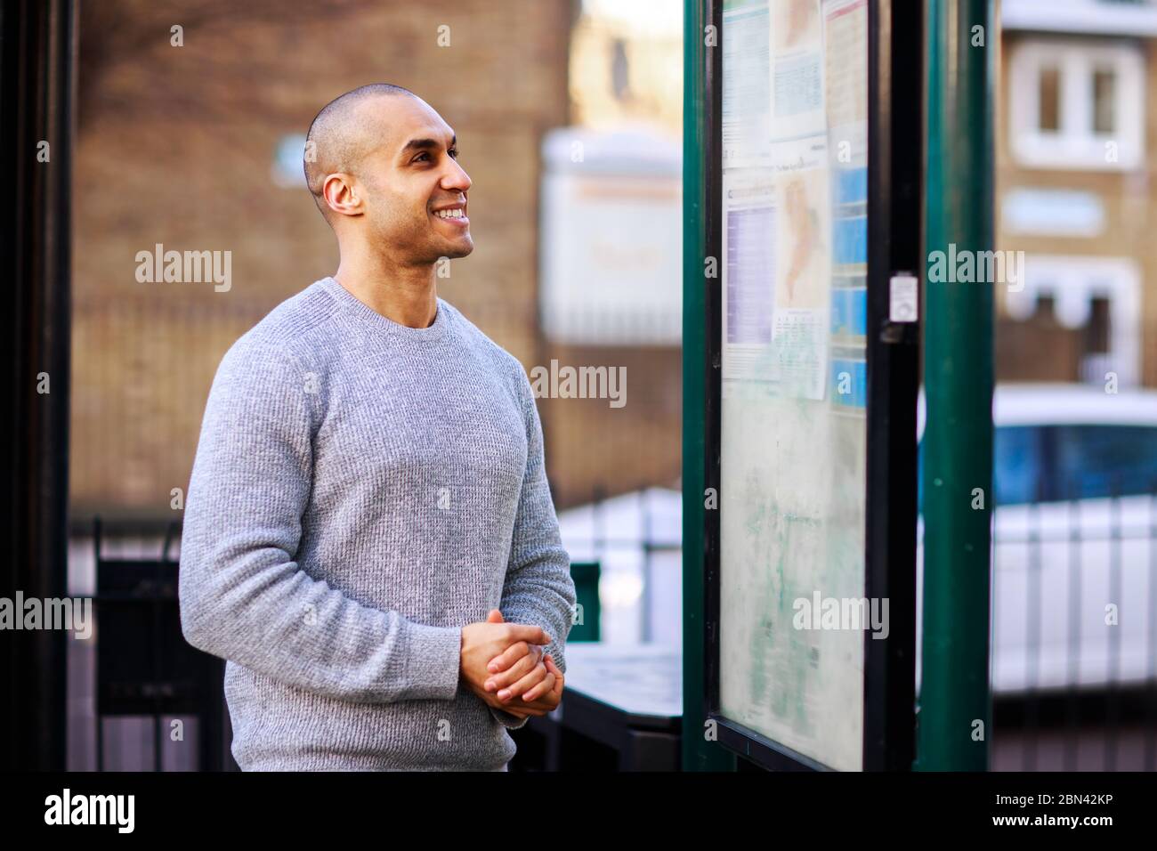 young man looking at a notice board Stock Photo - Alamy