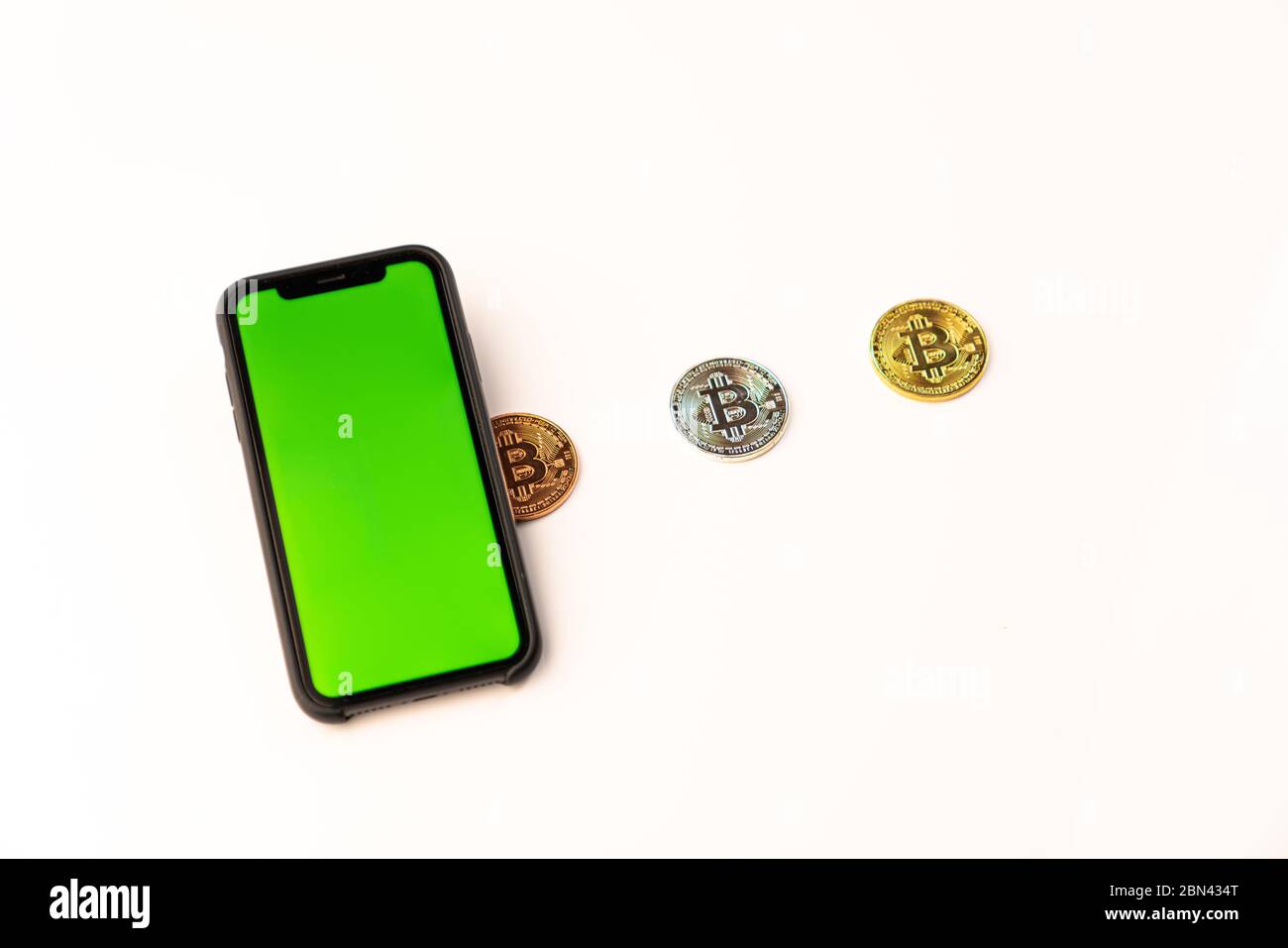 Bitcoin coins and phone with green screen on white background. Business ...